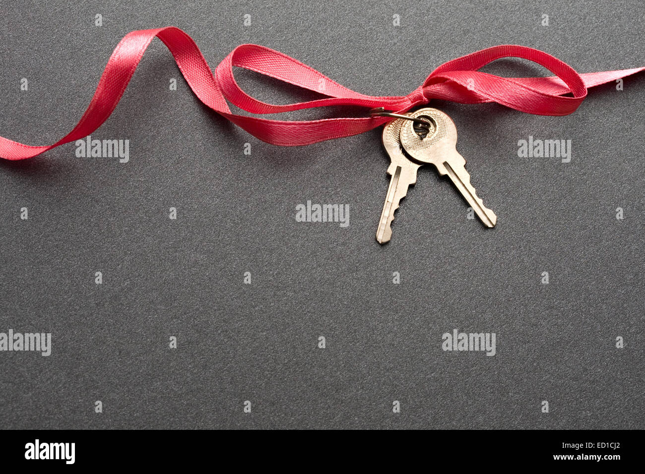Keys with ribbon on the grey background Stock Photo - Alamy