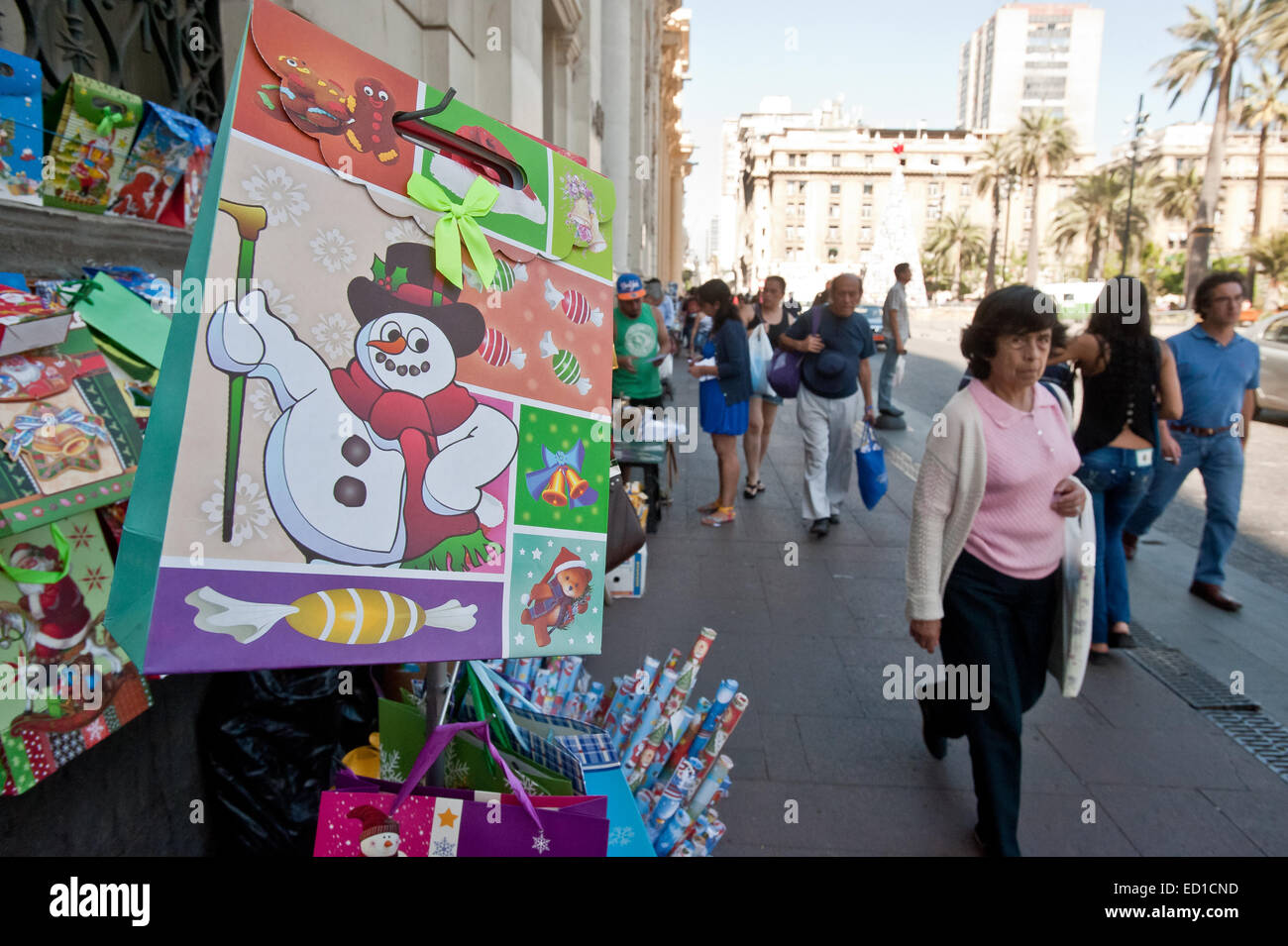 Santiago, Chile. 23rd Dec, 2014. People walk in front of a stand with ...