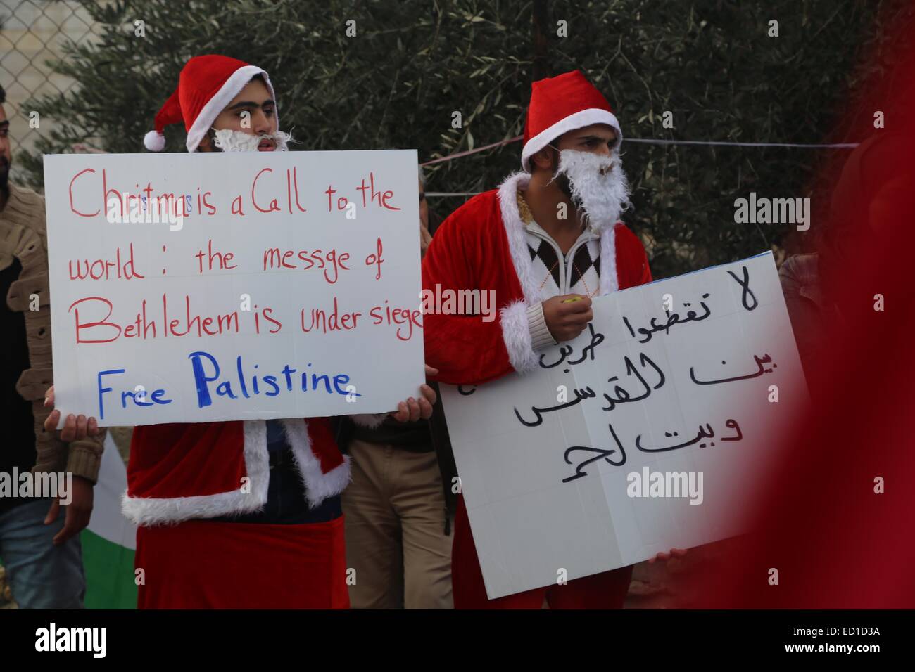Palestinian protesters dressed as Santa Claus argue with the members of ...