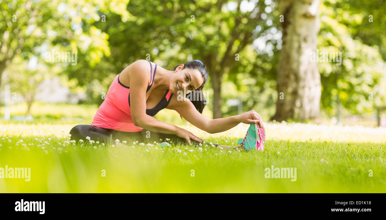 Smiling fit brunette stretching hi-res stock photography and images - Alamy