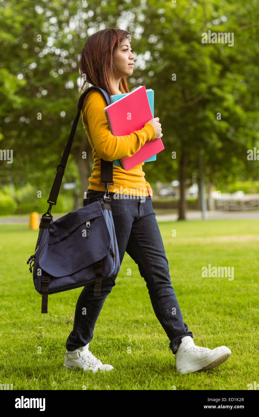 Female college student with books walking in park Stock Photo - Alamy