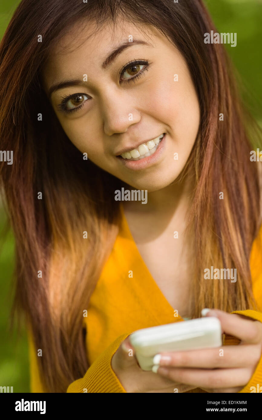 Beautiful woman text messaging in park Stock Photo - Alamy