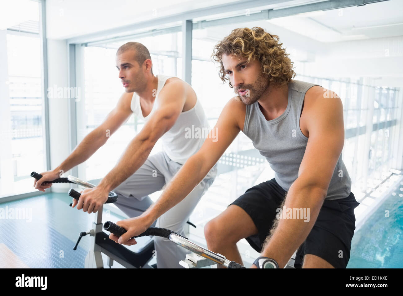 Men working on exercise bikes at gym Stock Photo - Alamy