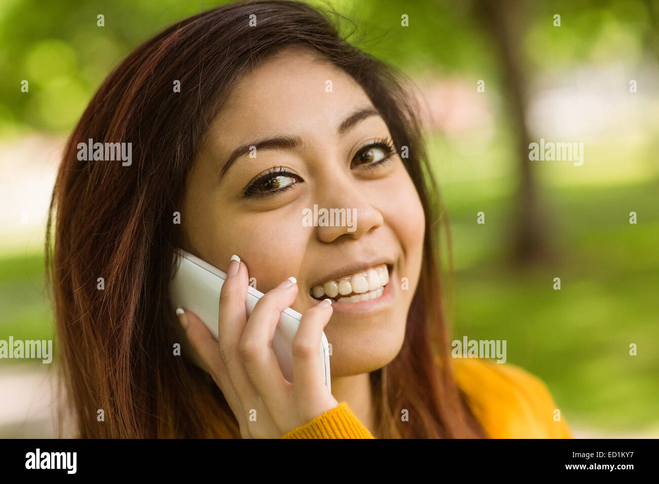 Woman using mobile phone in park Stock Photo - Alamy