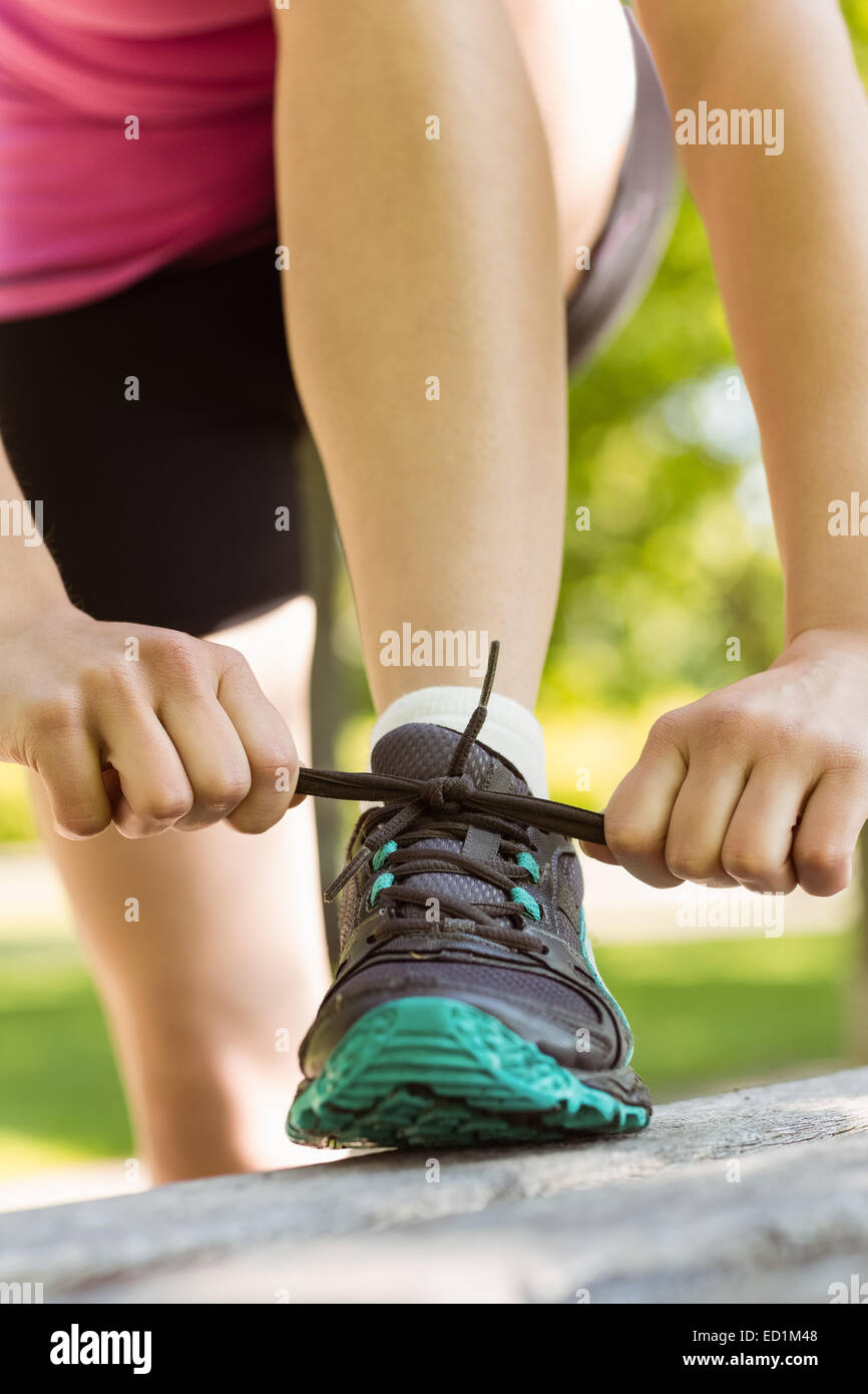 Fit woman tying her shoelace Stock Photo - Alamy