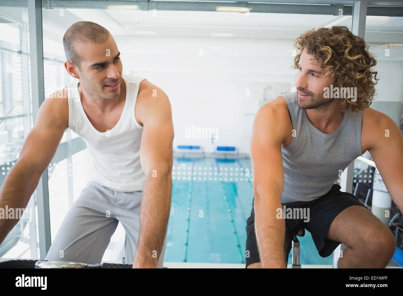 Fit men working on exercise bikes at gym Stock Photo - Alamy