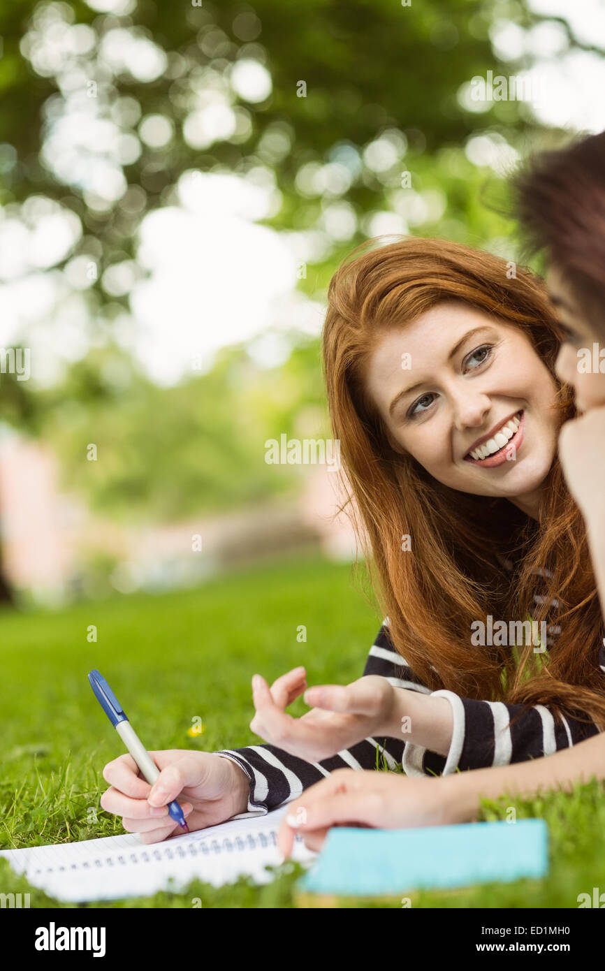 Relaxed female students with books in park Stock Photo - Alamy