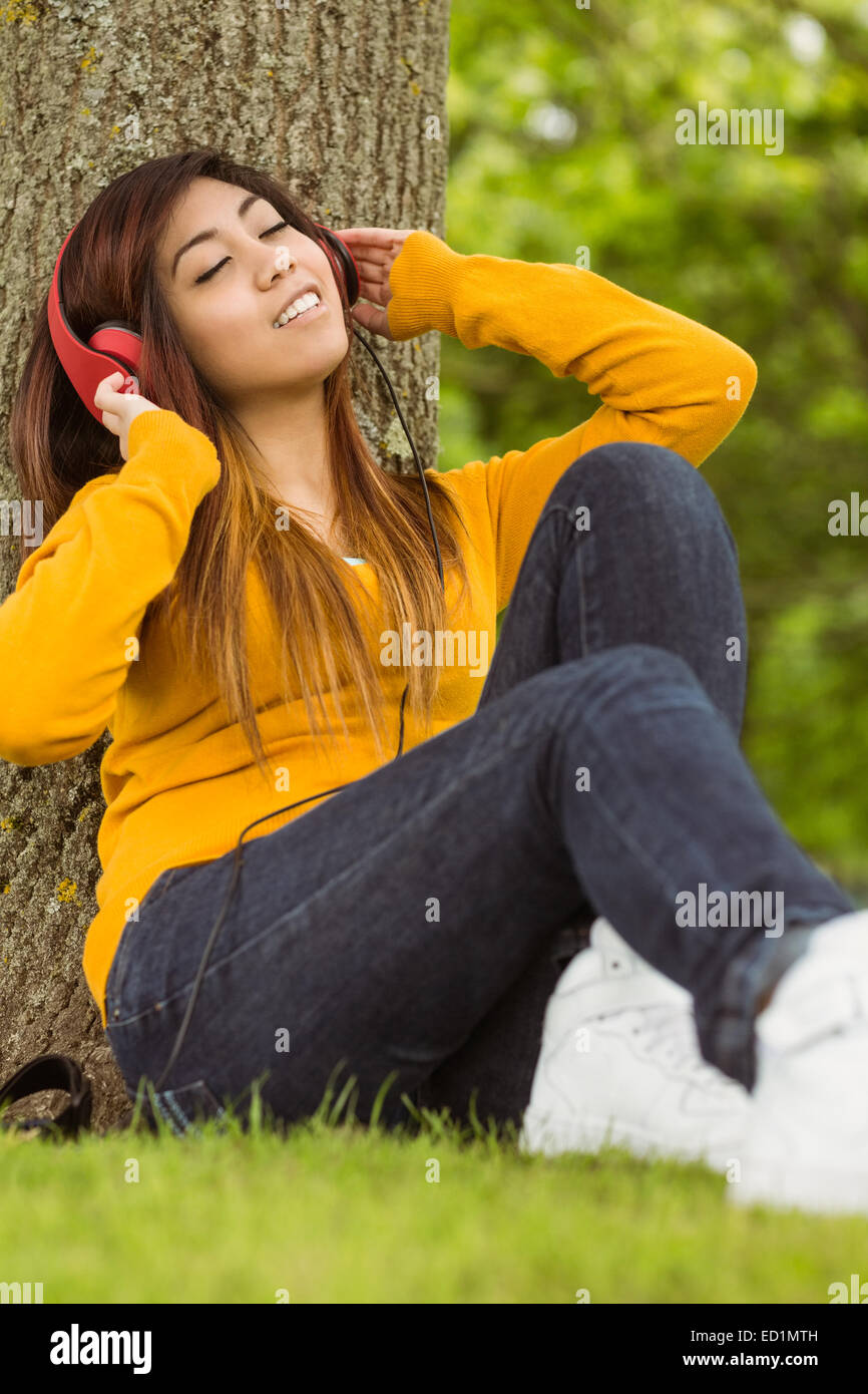 Relaxed woman enjoying music in park Stock Photo - Alamy