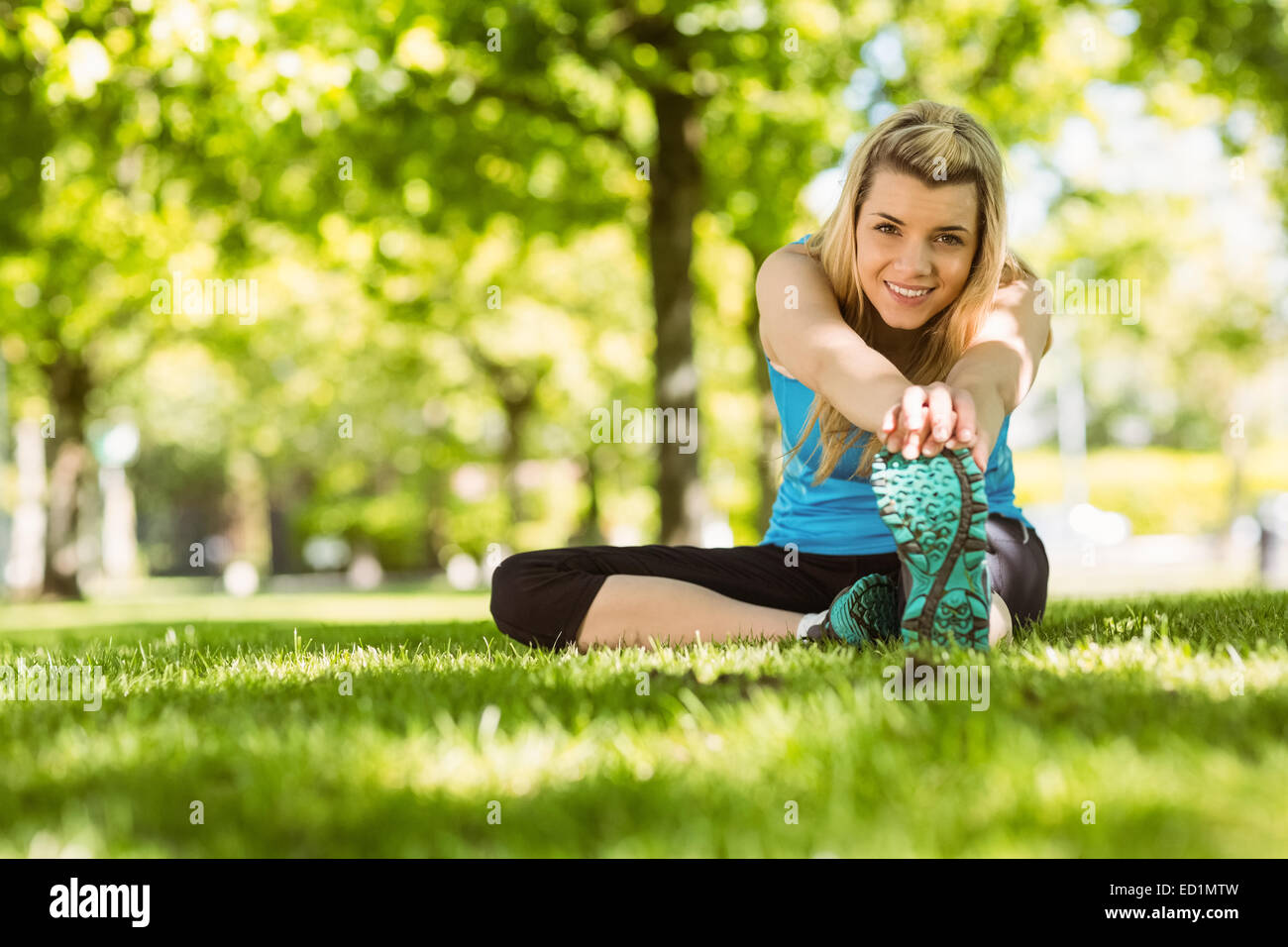 Fit blonde stretching on the grass Stock Photo - Alamy