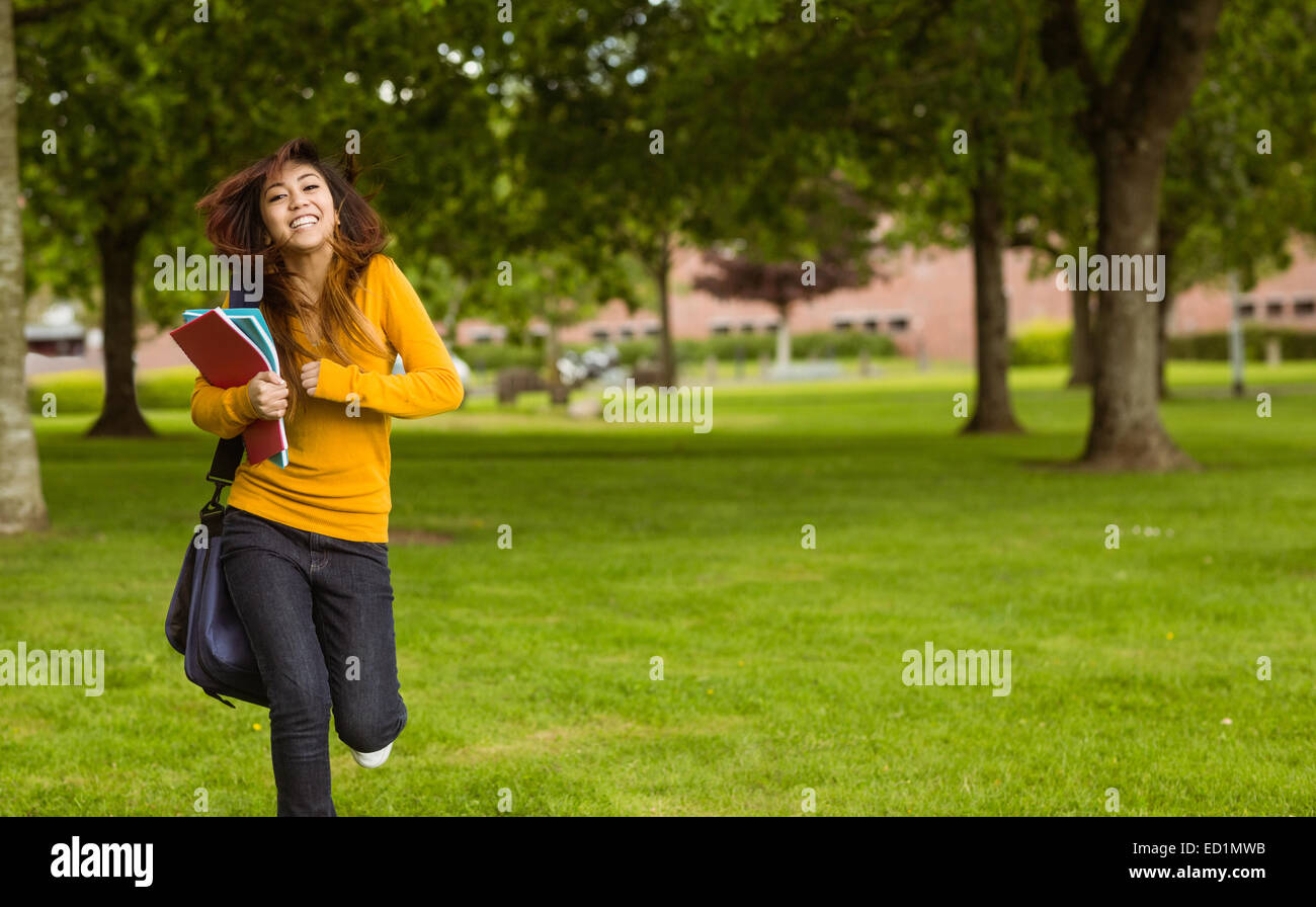 Female college student with books running in park Stock Photo - Alamy