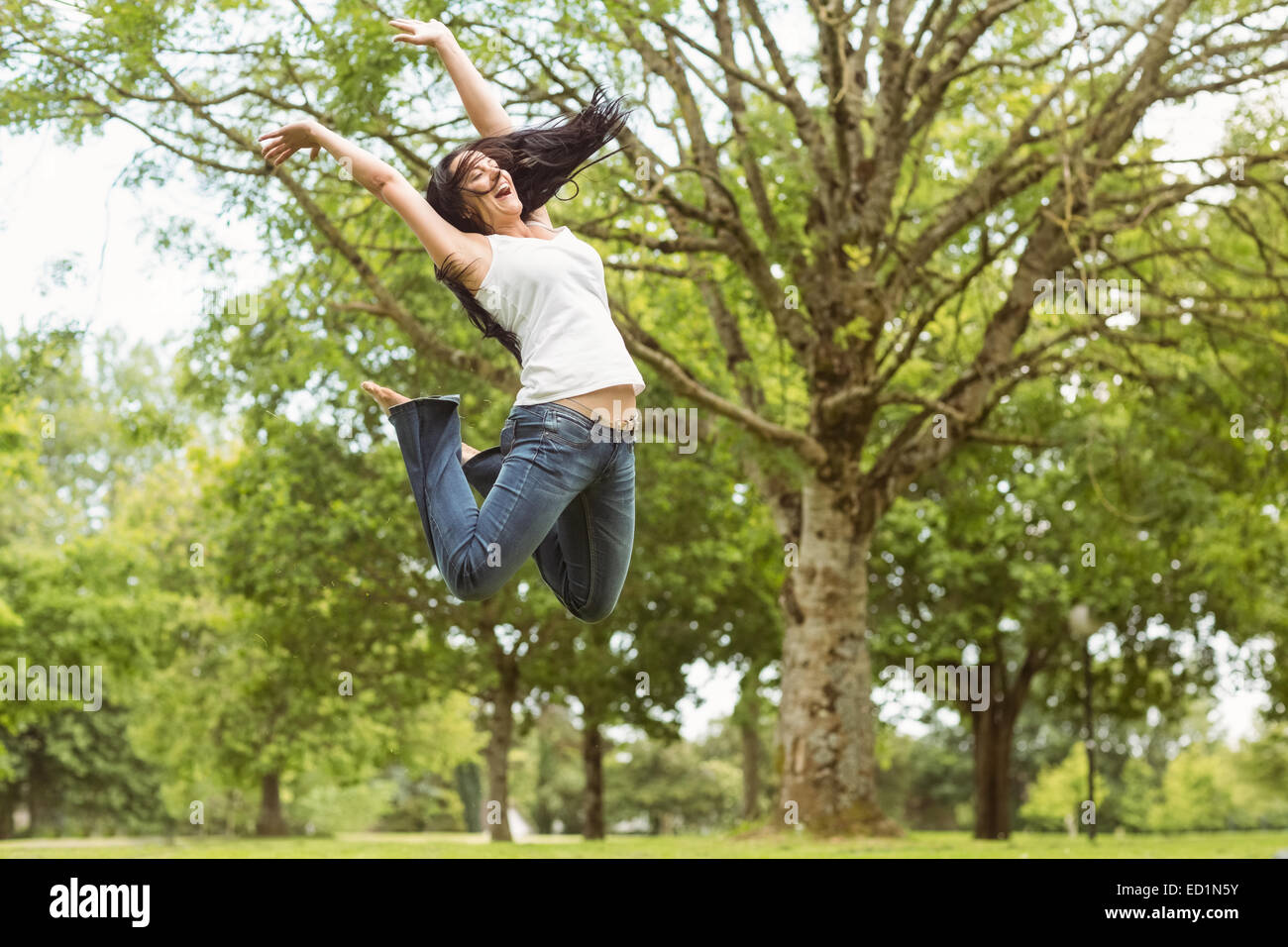 Excited and happy brunette jumping Stock Photo - Alamy