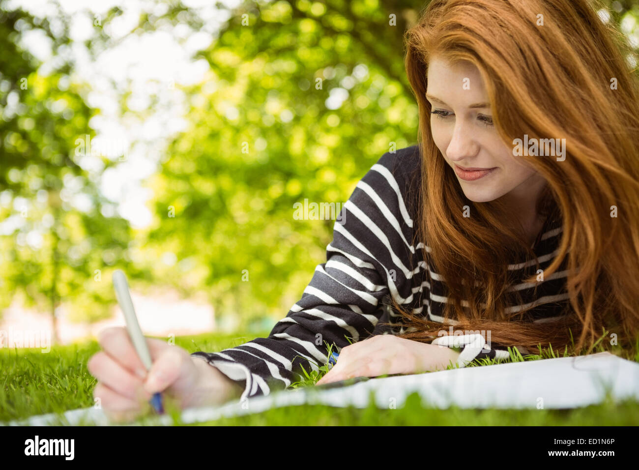 Female student doing homework in park Stock Photo - Alamy
