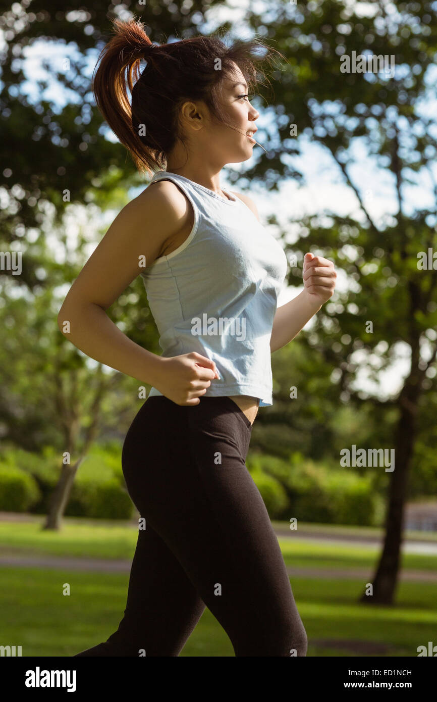 Side view of healthy woman jogging in park Stock Photo - Alamy