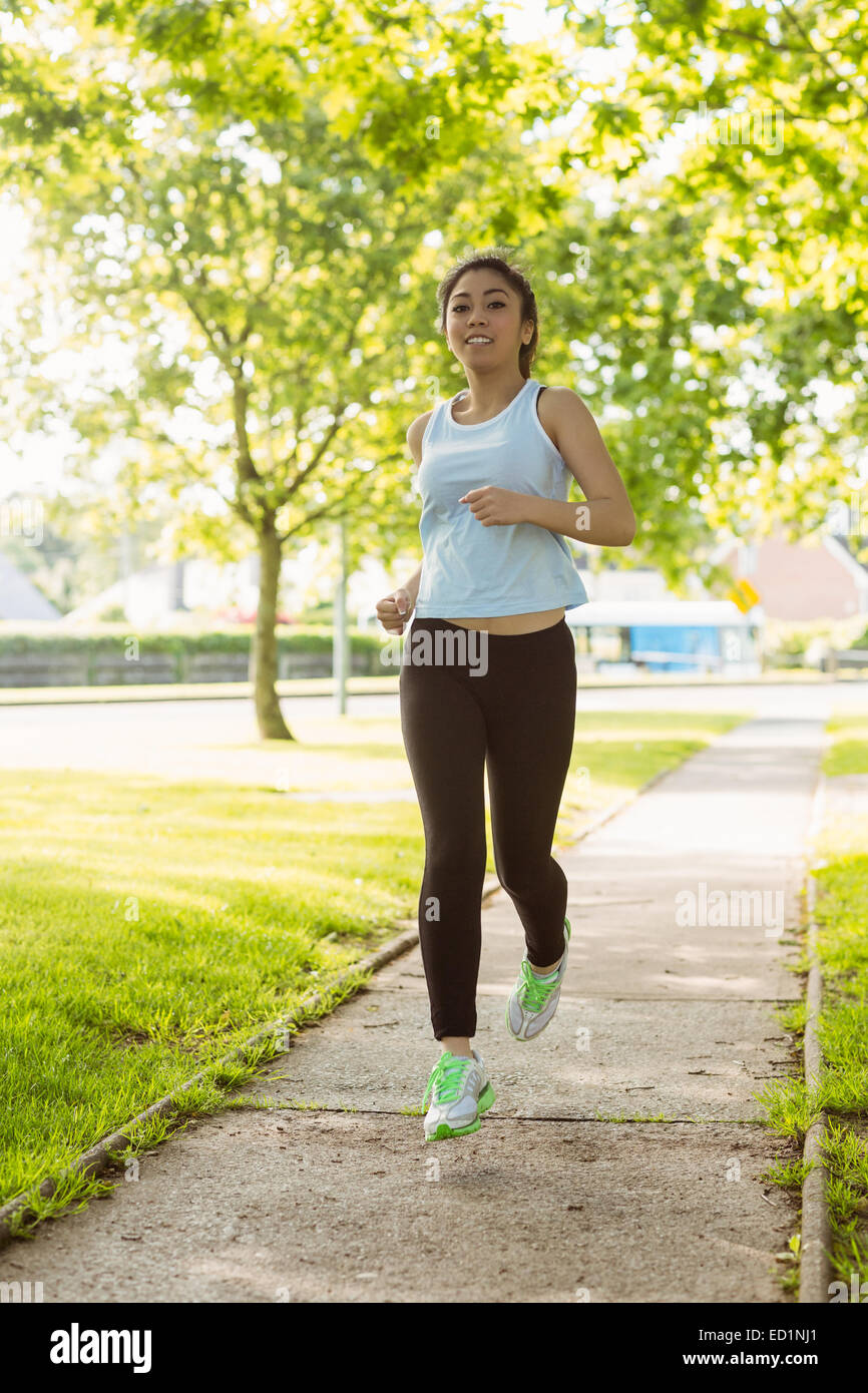 Fit young woman jogging through the park Stock Photo - Alamy