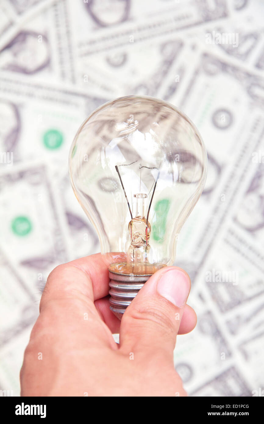 light blub in hand with money background Stock Photo - Alamy