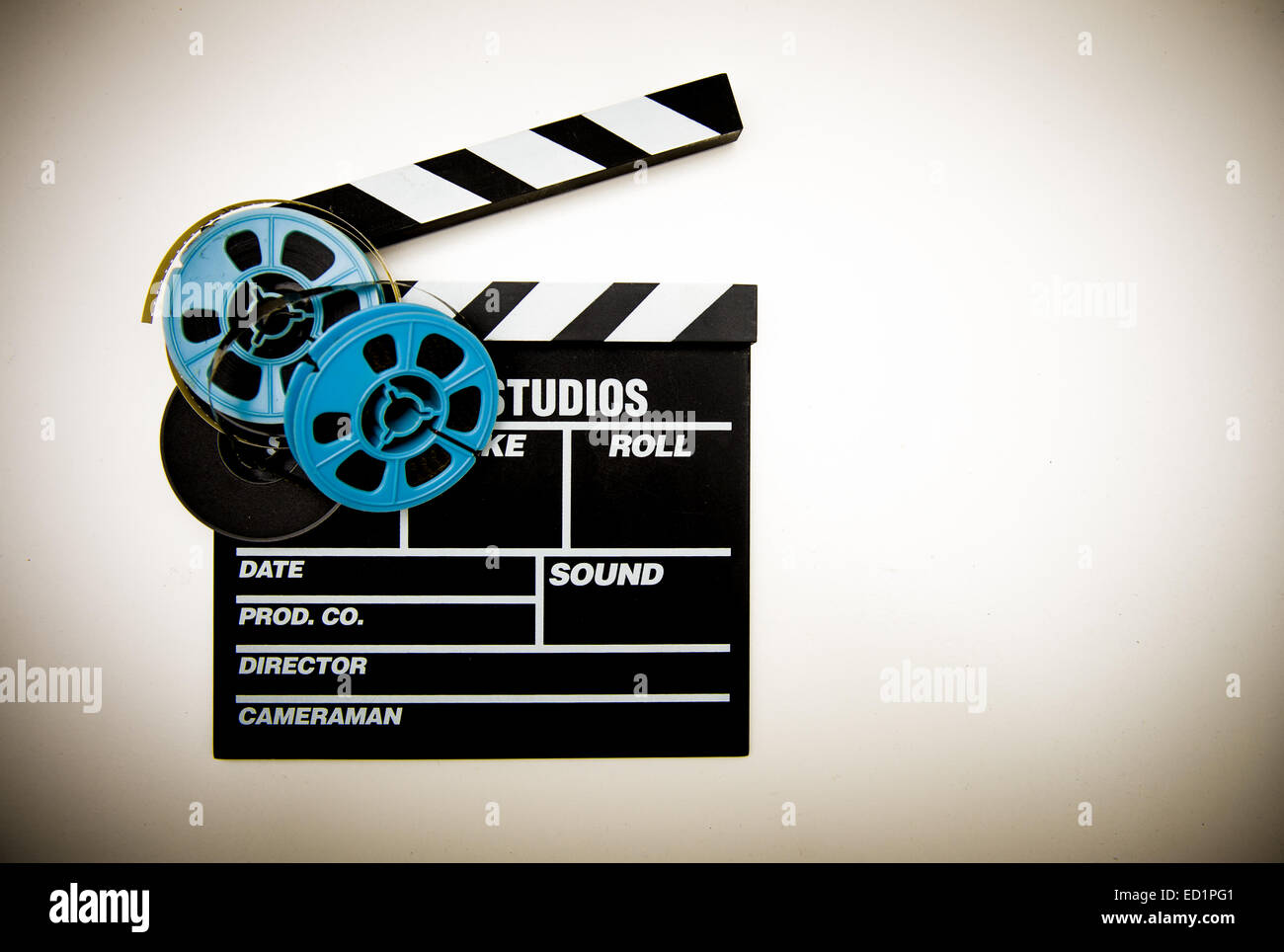 Clapper board with 8mm film reels in white background and vintage color ...