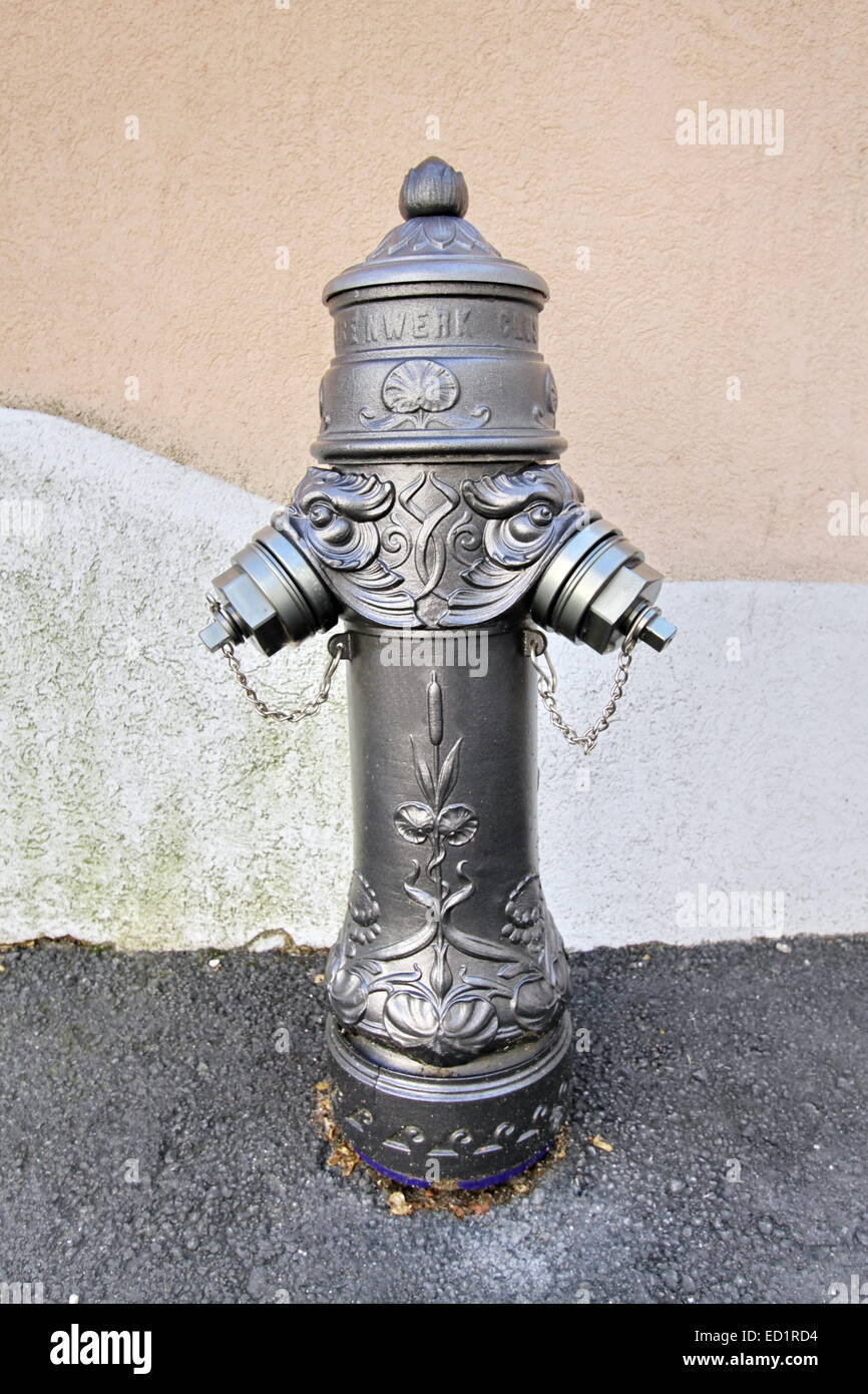 Old gray fire hydrant in front of a wall Stock Photo - Alamy