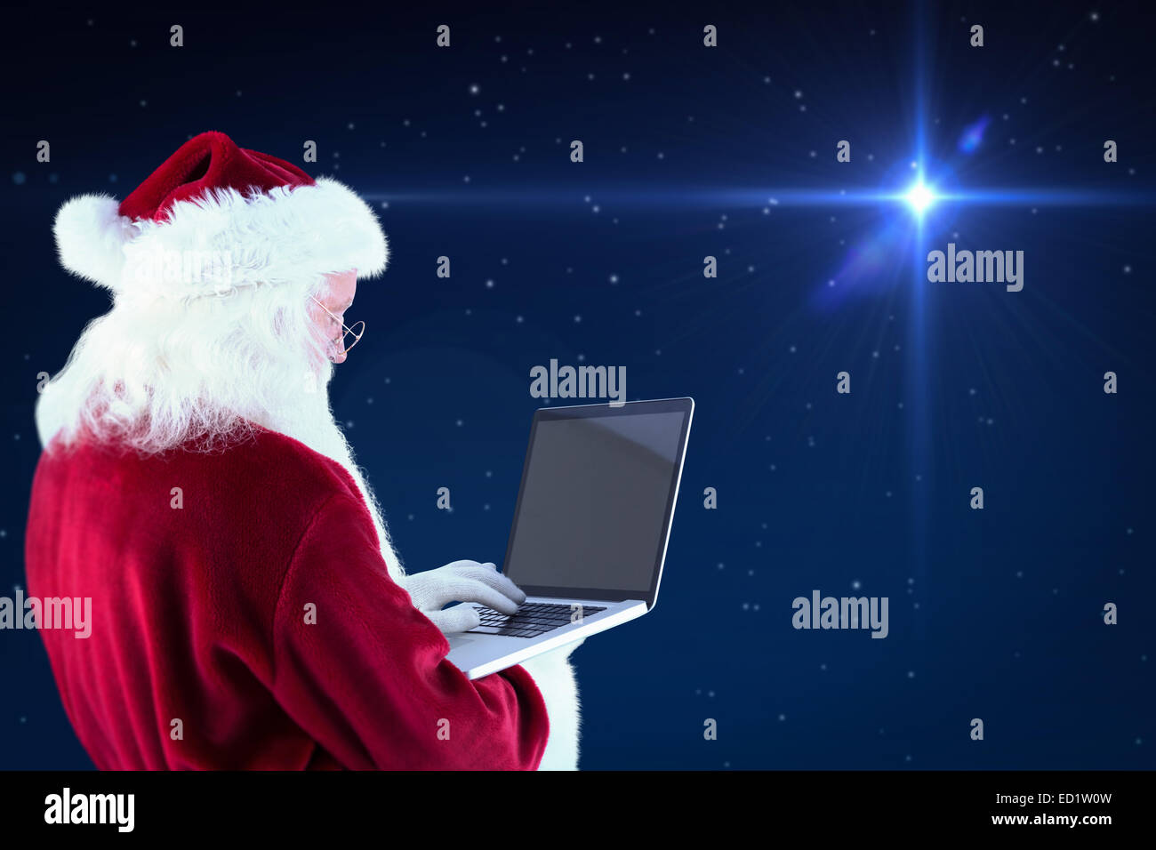 Composite image of santa claus uses a laptop Stock Photo - Alamy