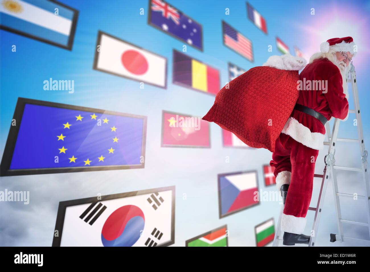 Composite image of santa steps up a ladder Stock Photo - Alamy