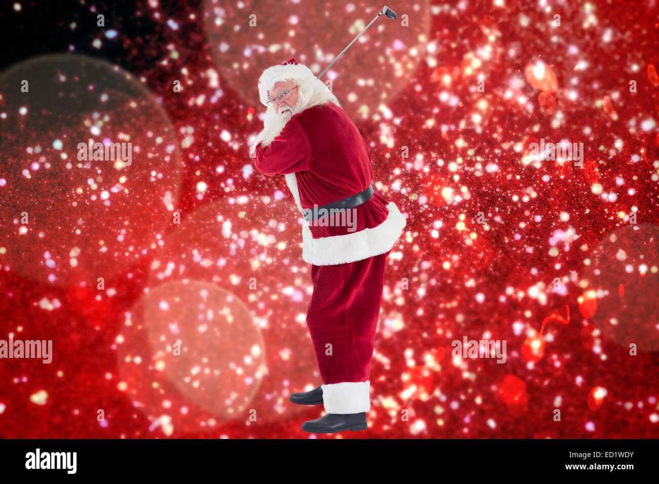 Composite image of santa claus swings his golf club Stock Photo - Alamy