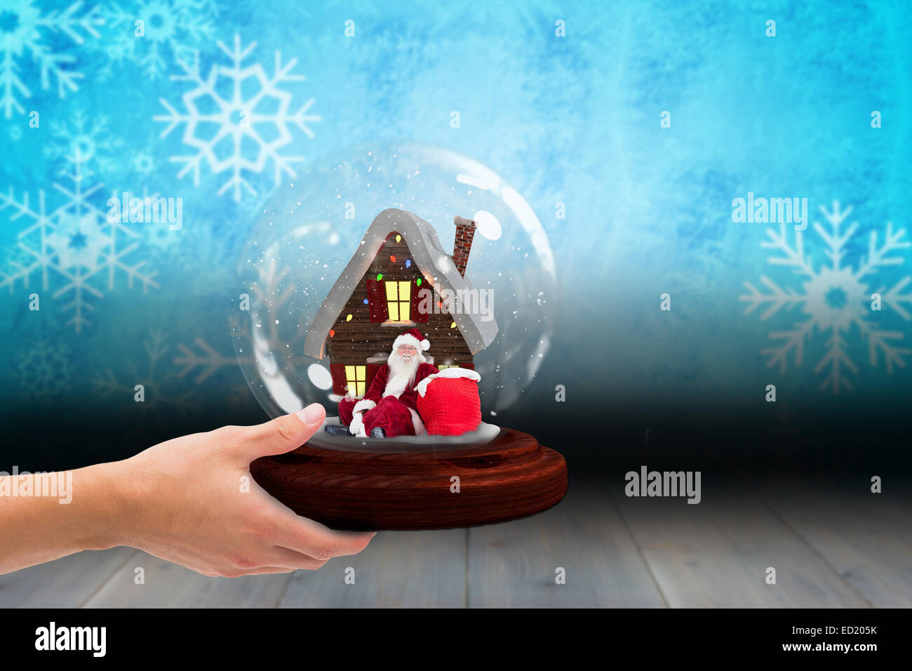 Composite image of hand holding snow globe Stock Photo - Alamy