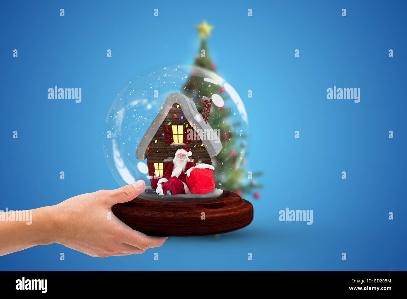 Composite image of hand holding snow globe Stock Photo - Alamy