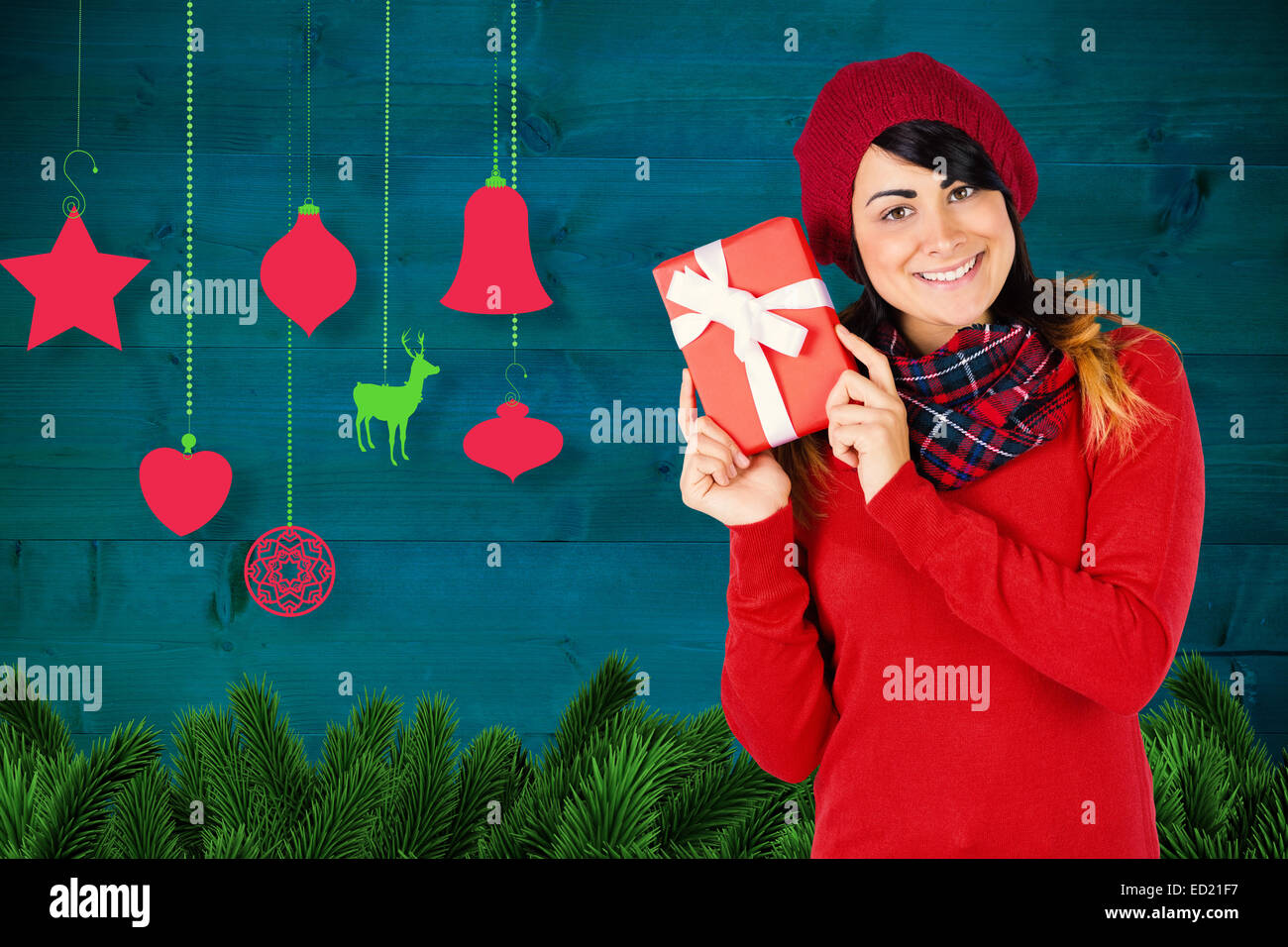 Composite image of brunette in red hat holding a gift Stock Photo - Alamy
