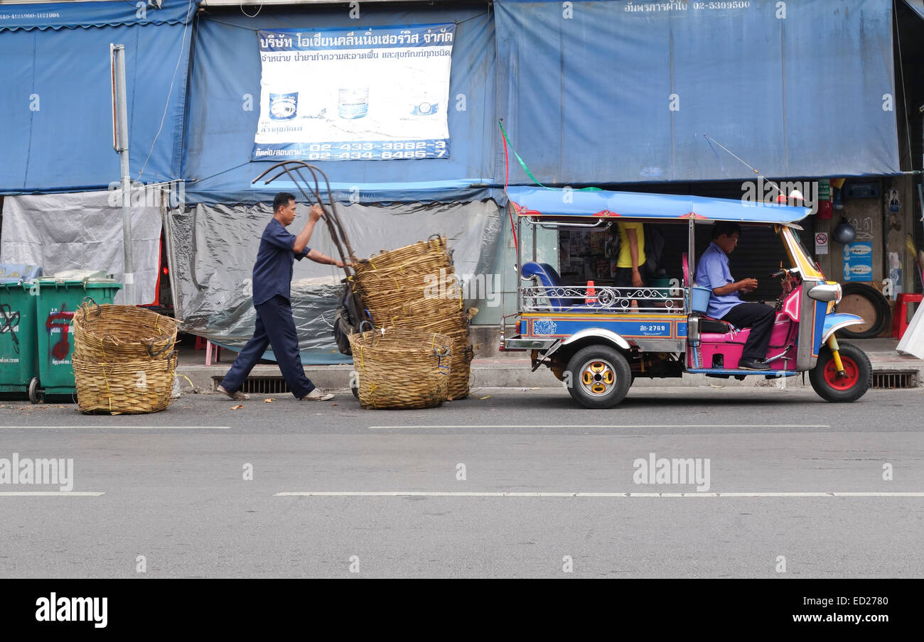 Tuk-tuk and man loading baskets in a street in Bangkok, Thailand ...