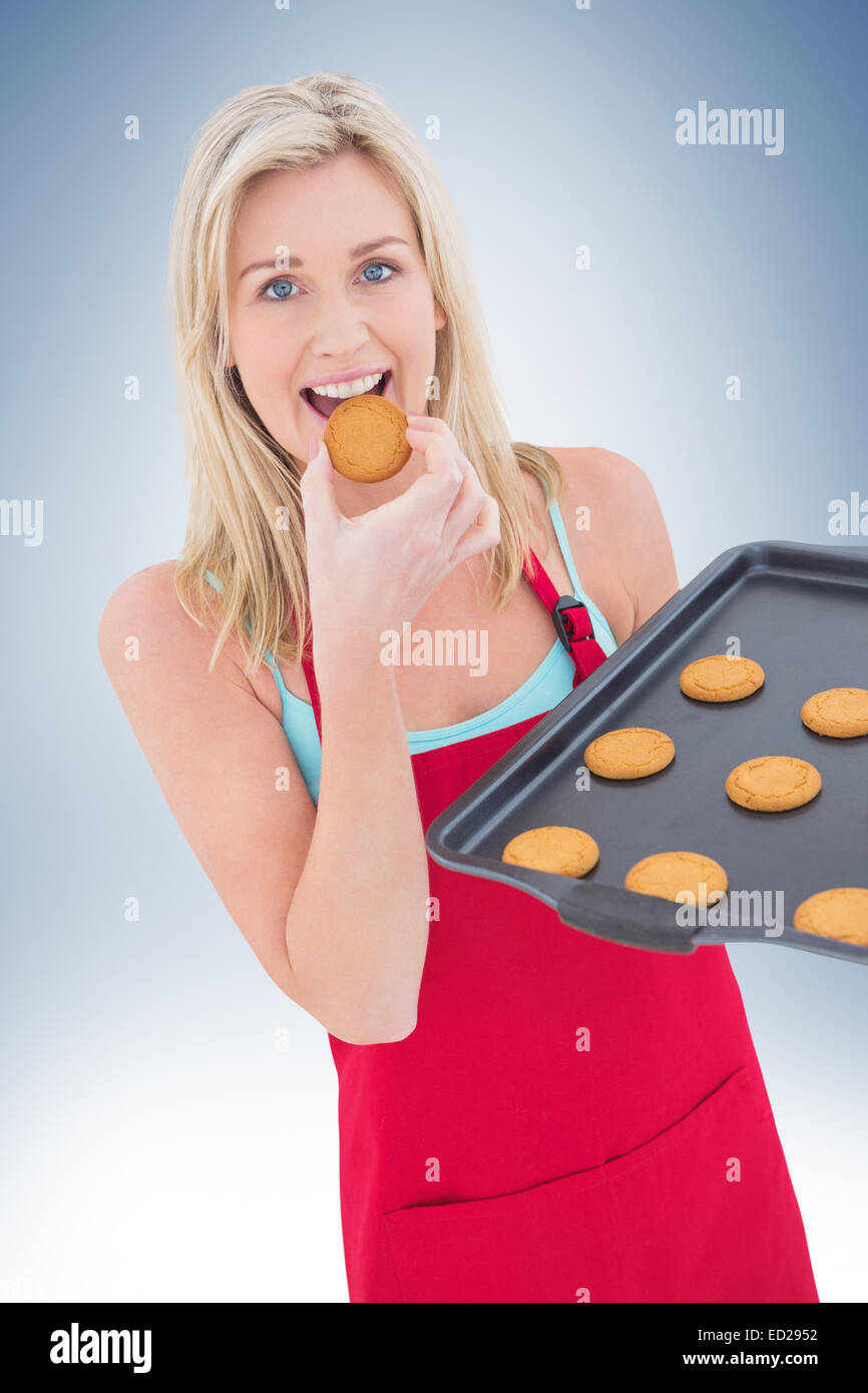 Happy blonde eating hot cookies Stock Photo - Alamy