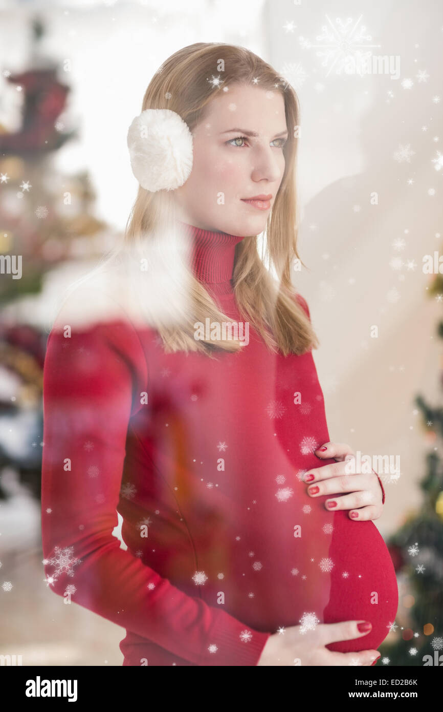 Composite image of pretty pregnant woman caressing her belly while ...