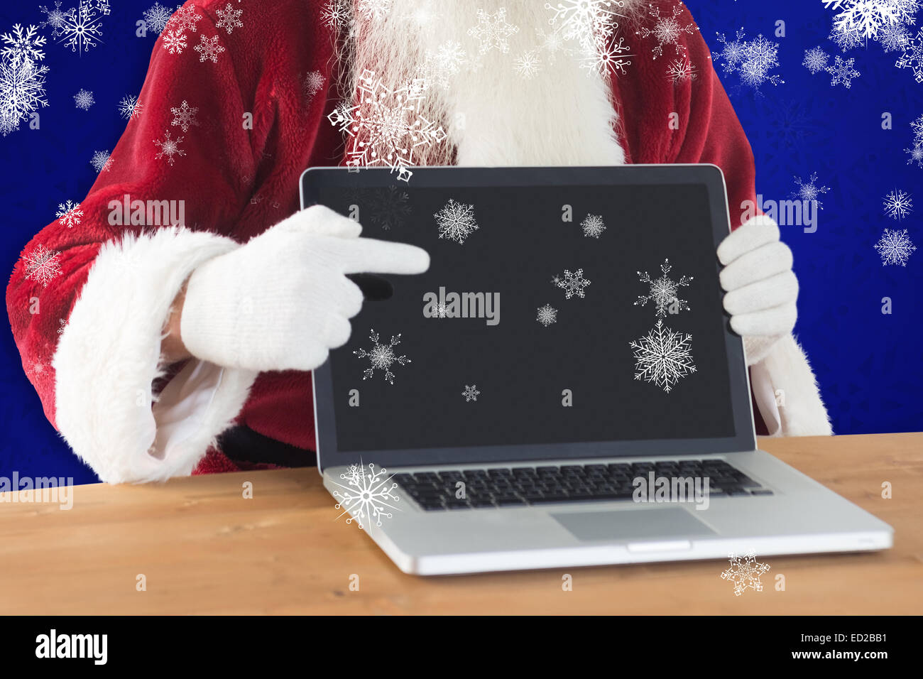 Composite image of happy santa showing laptop screen Stock Photo - Alamy