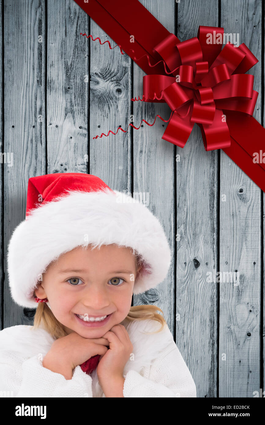Composite image of cute little girl wearing santa hat Stock Photo - Alamy