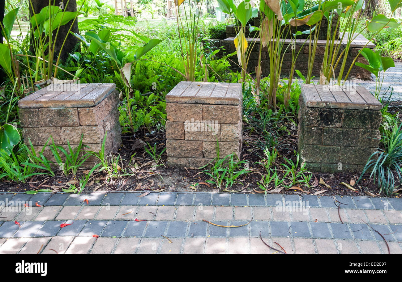 Stone stool in the small garden of urban park Stock Photo - Alamy