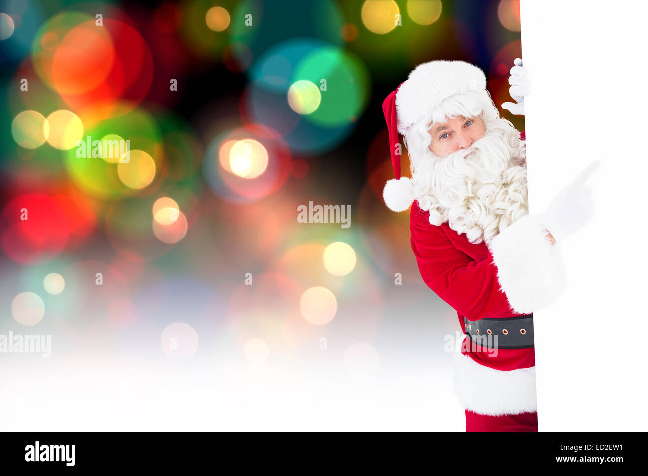 Composite image of smiling santa claus pointing poster Stock Photo - Alamy