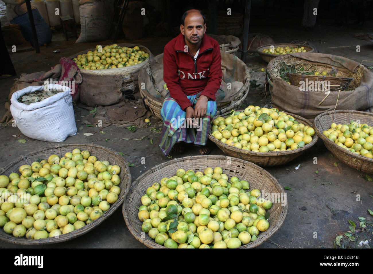 A Bangladeshi lemon's vendor he waits for customers at a wholesale ...