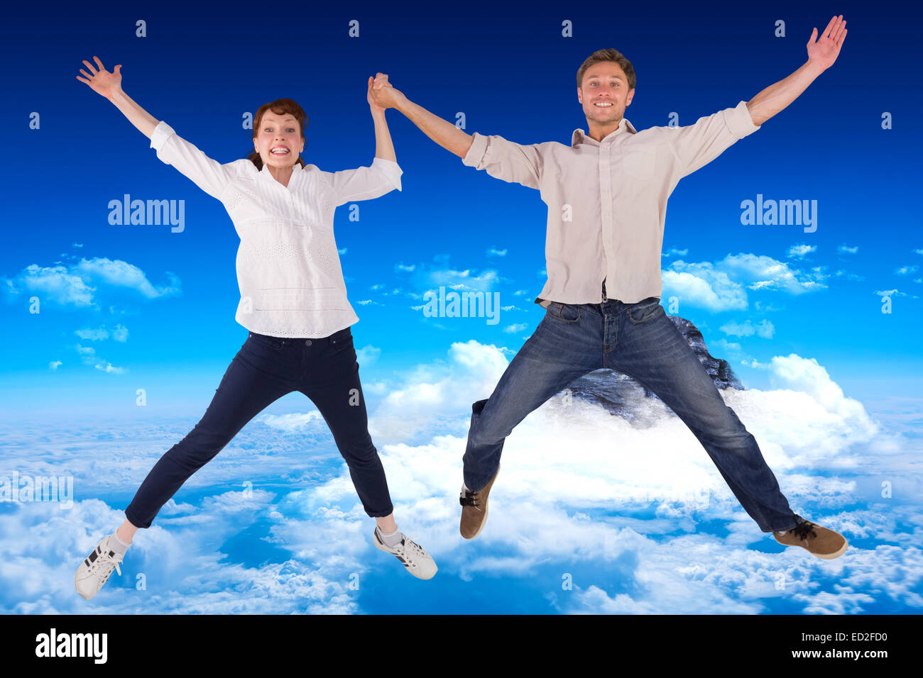 Composite image of couple jumping and holding hands Stock Photo - Alamy