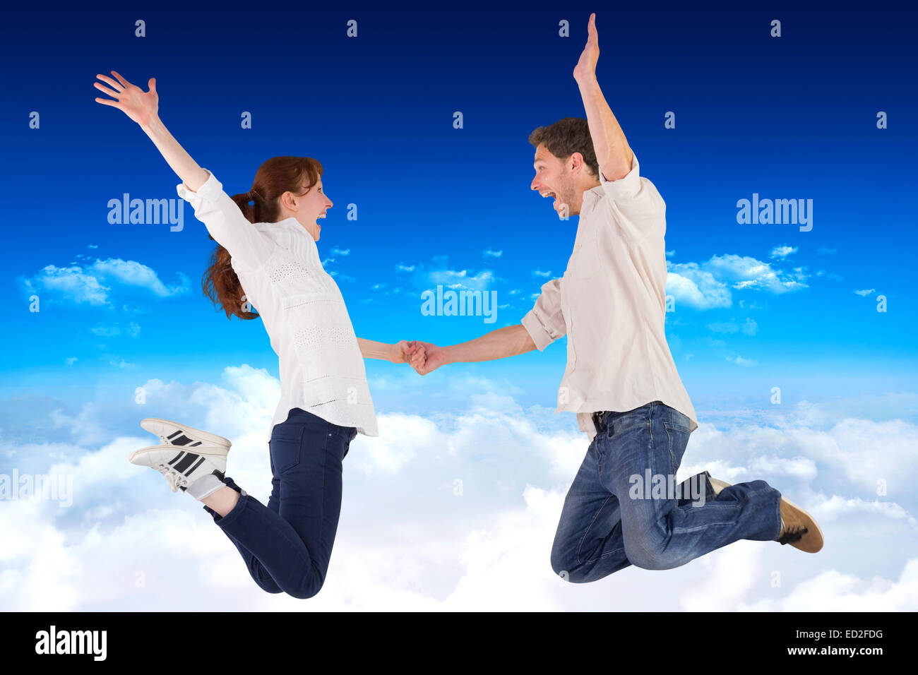 Composite image of couple jumping and holding hands Stock Photo - Alamy