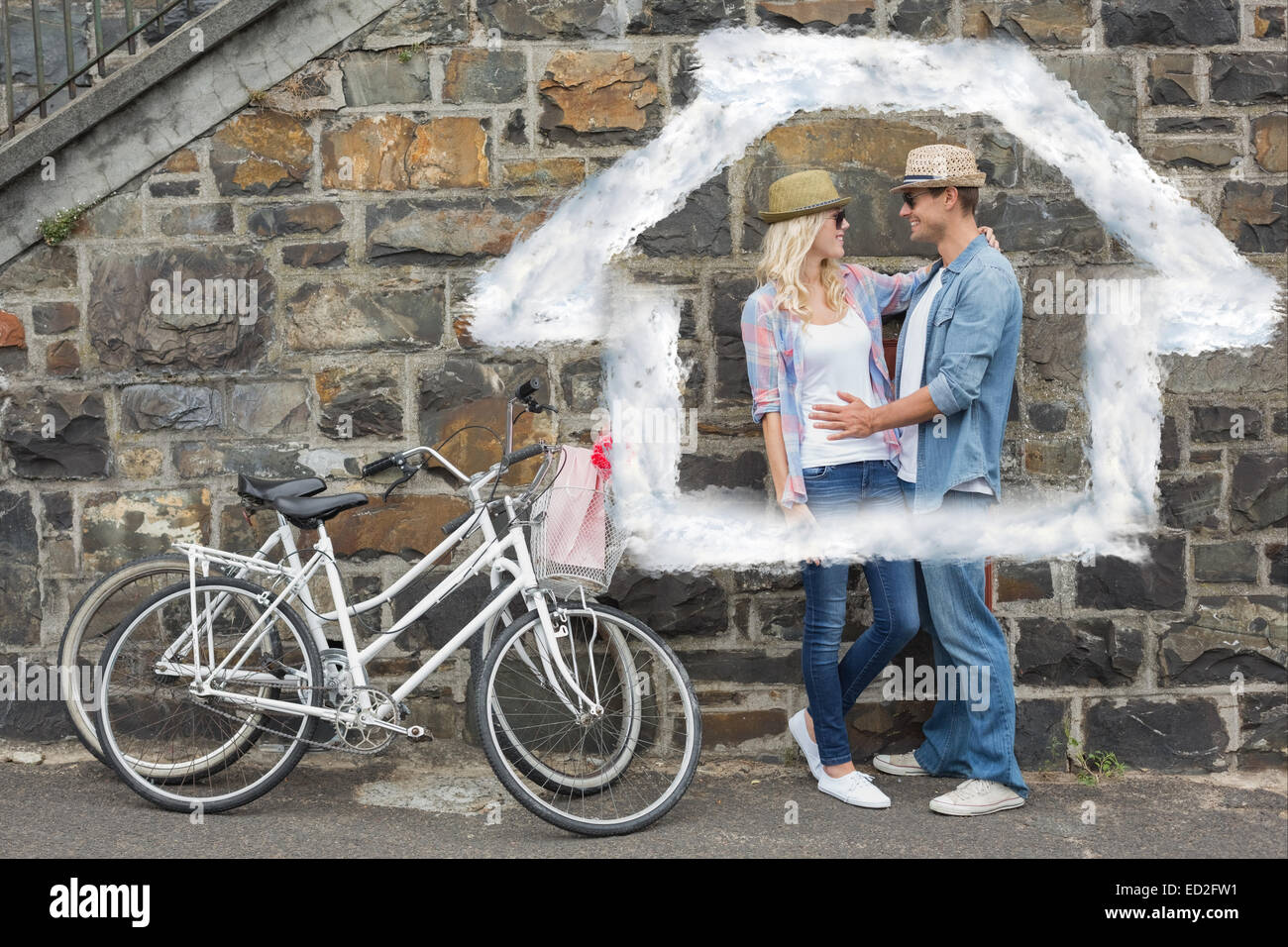 Composite image of hip young couple hugging by brick wall with their ...