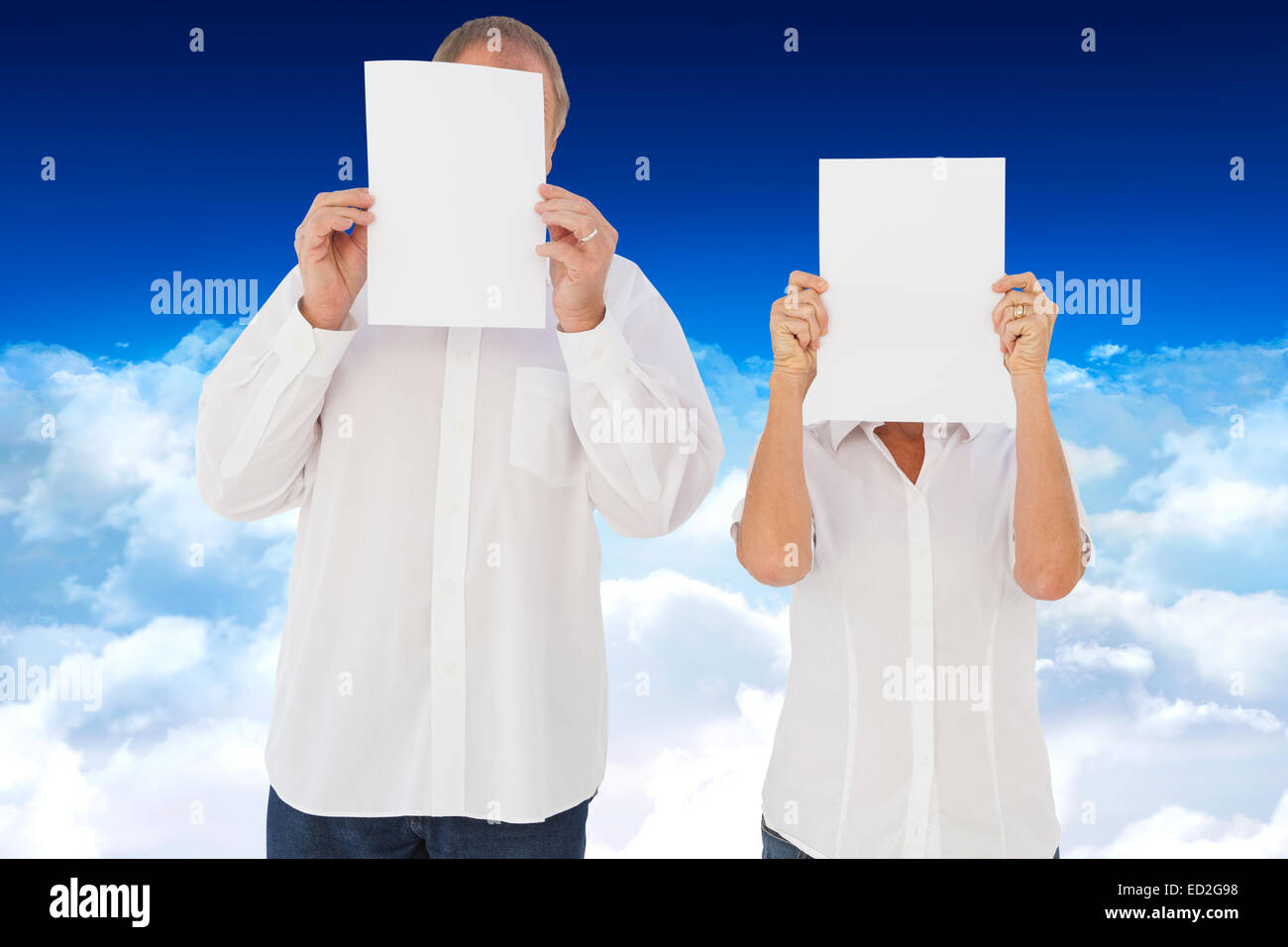 Composite image of couple holding paper over their faces Stock Photo ...