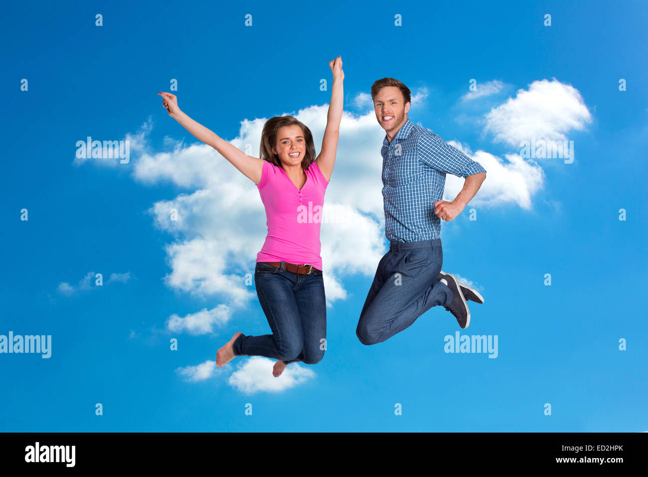 Composite image of cheerful young couple jumping Stock Photo - Alamy