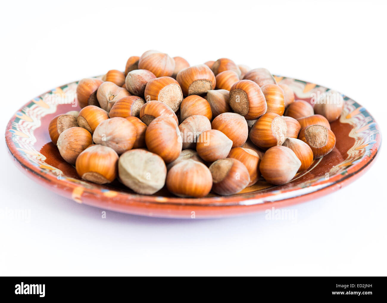 Unpeeled hazelnuts in a ceramic plate. Healthy organic eating Stock ...