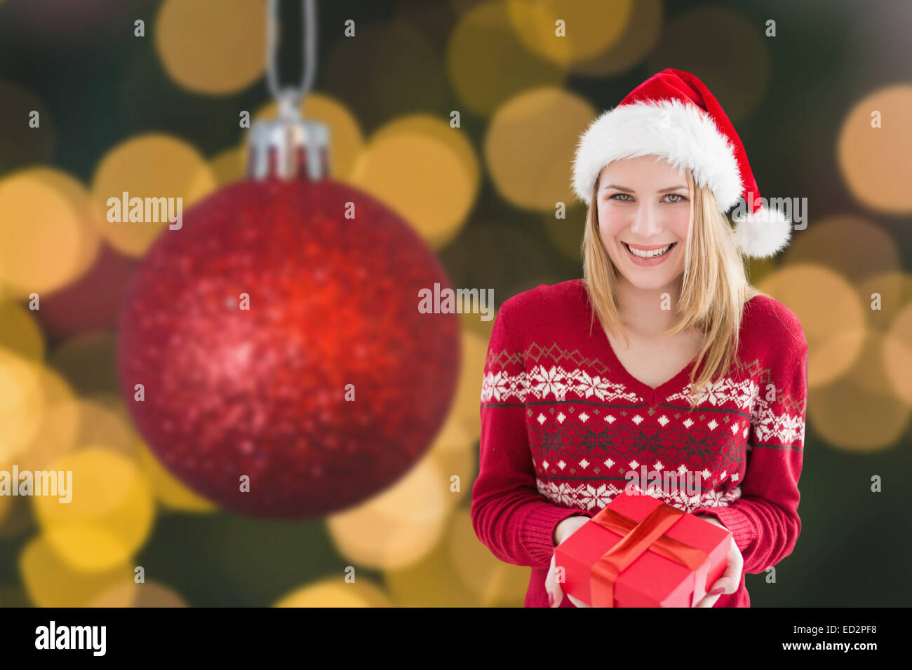 Composite image of woman smiling with present in hands Stock Photo - Alamy