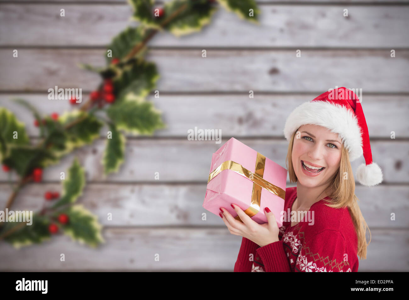 Composite image of woman smiling with present in hands Stock Photo - Alamy