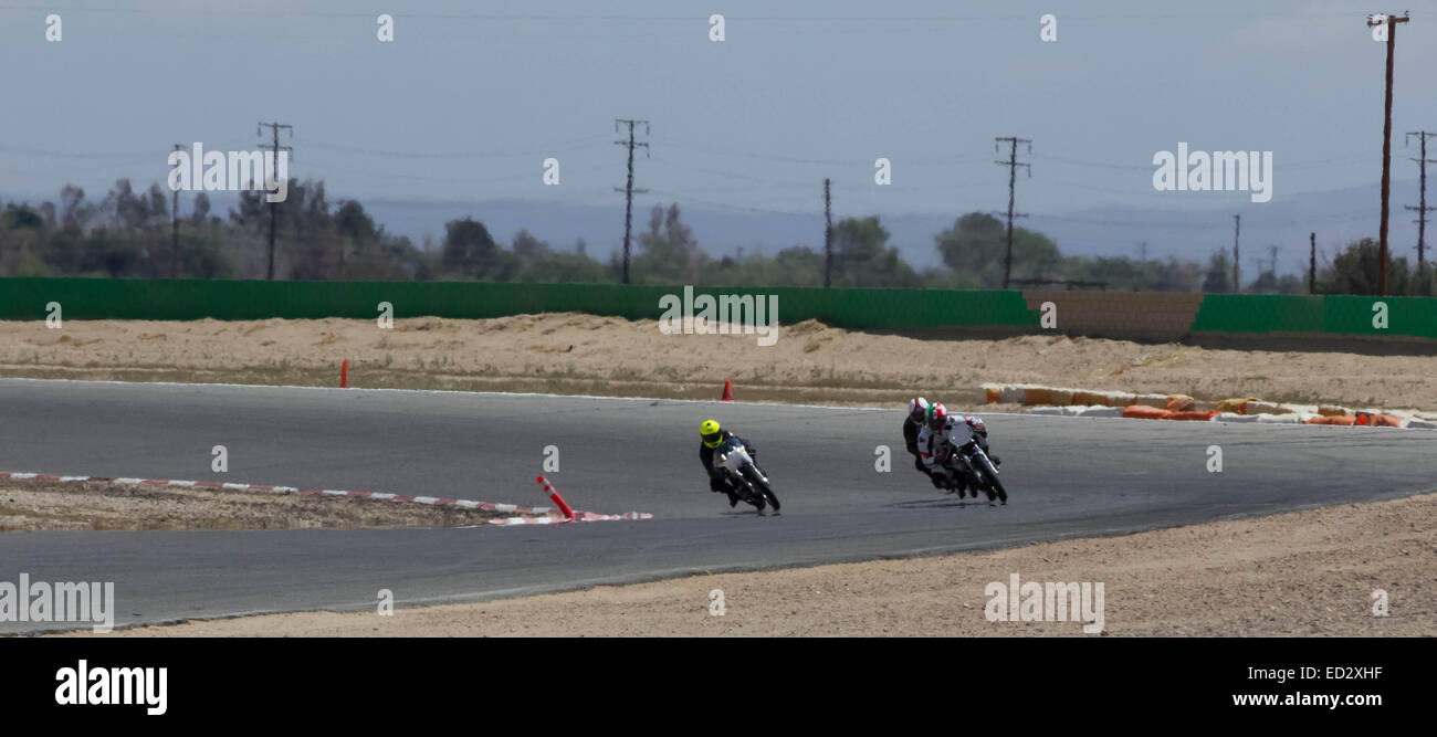 Three motorcyclists race their machines on a road racing track Stock ...