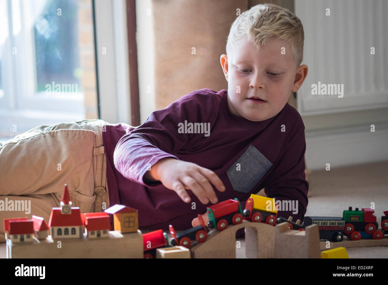 Boy playing with wooden train set Stock Photo - Alamy
