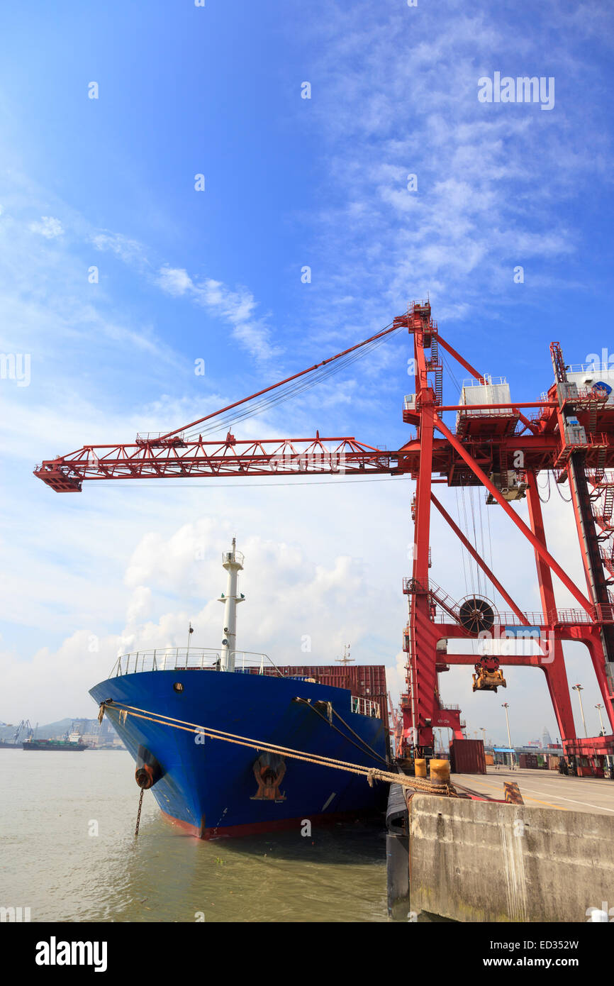 Frontal view of a container ship with a gantry cranes loading cargo ...