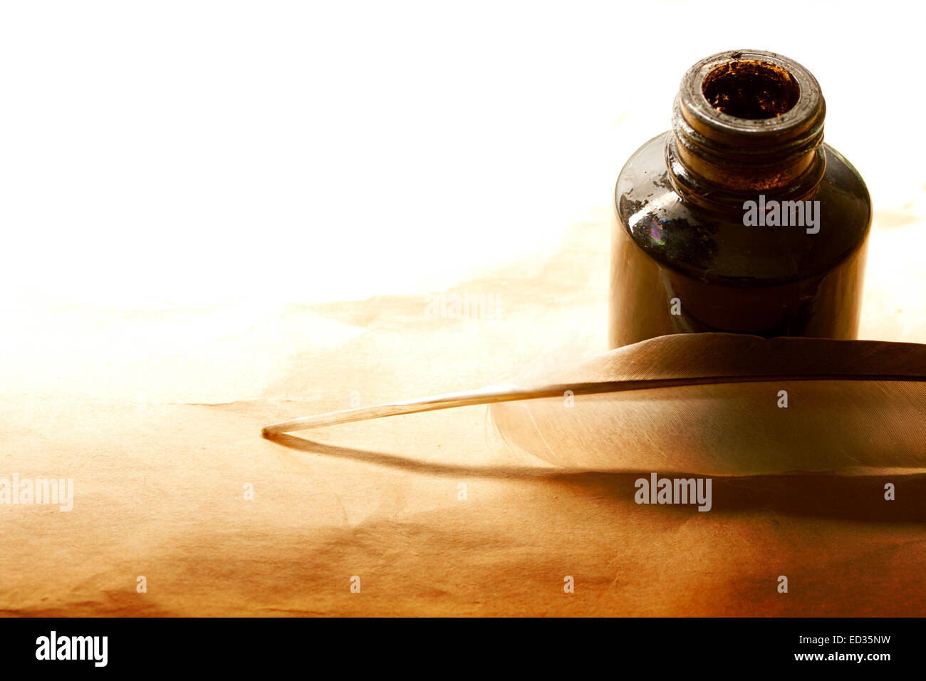 Feather and ink bottle isolated on paper background Stock Photo - Alamy