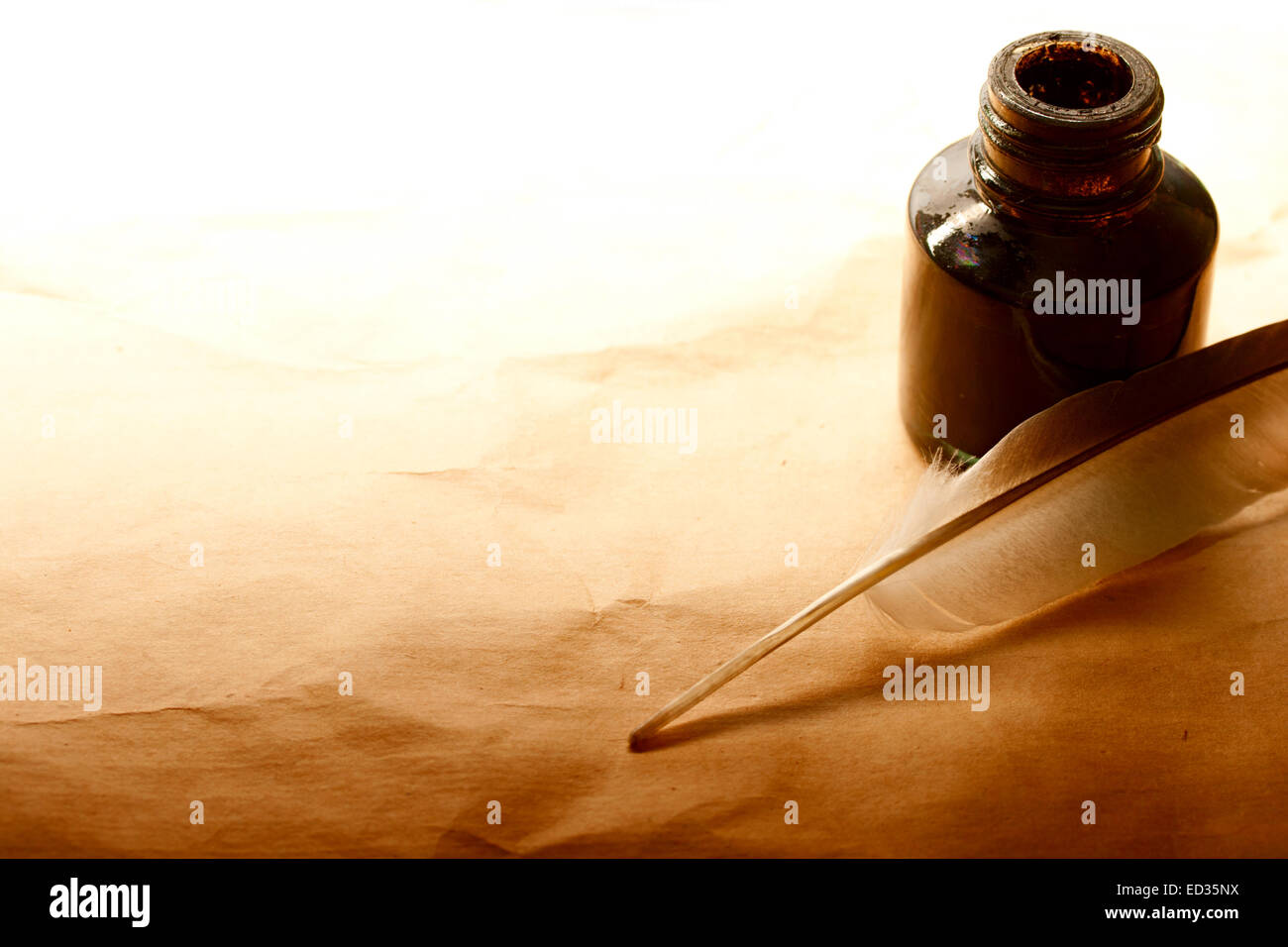 Feather and ink bottle isolated on paper background Stock Photo - Alamy