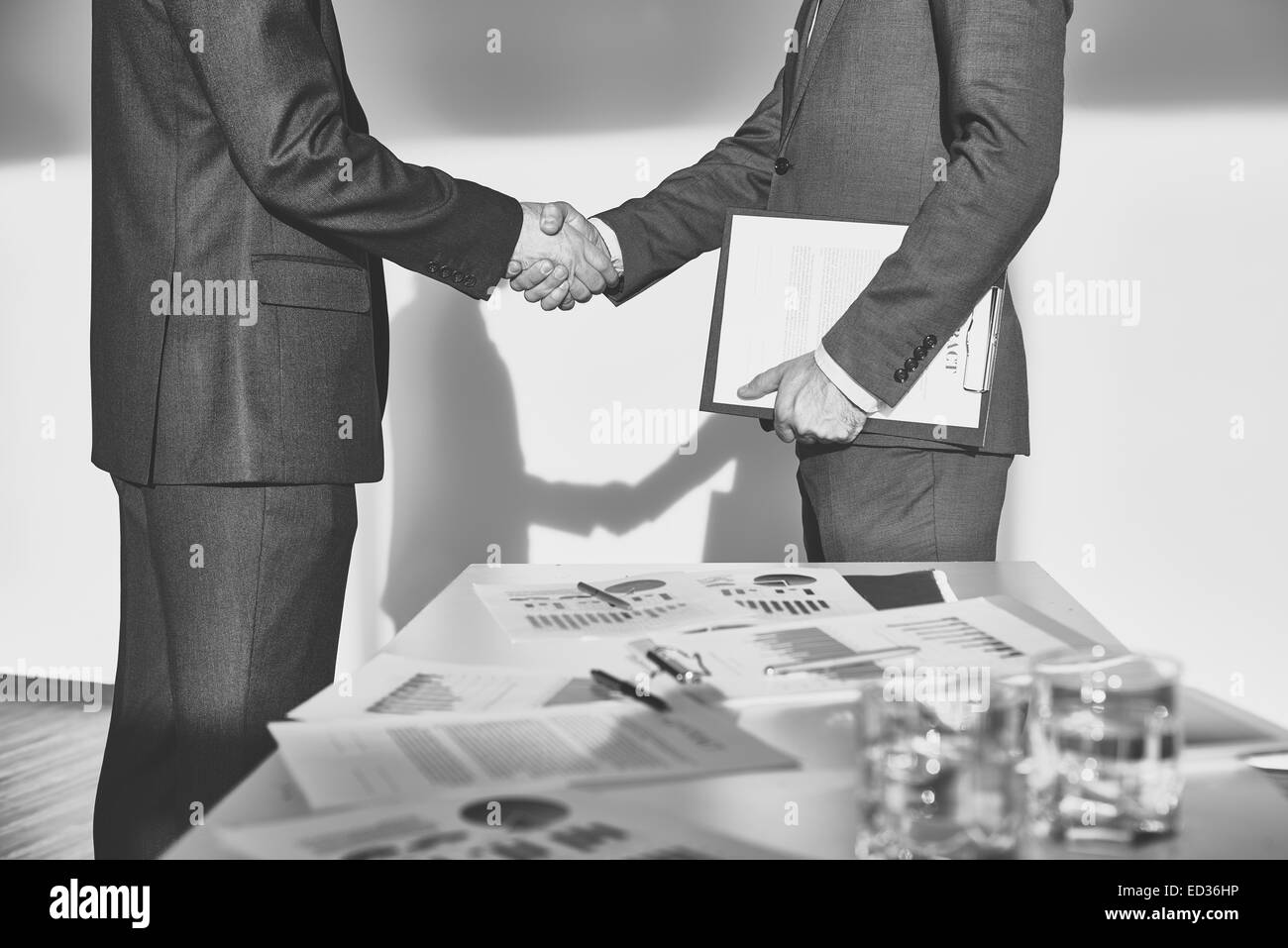 Two businessmen in formalwear handshaking after signing contract Stock ...