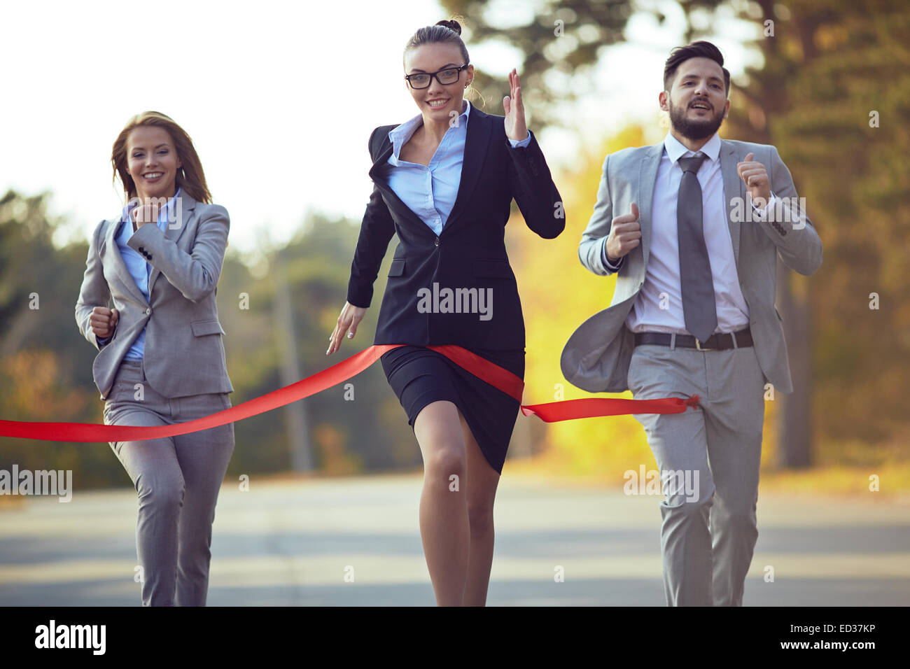 Competitive businesswoman coming to finish first with her colleagues ...